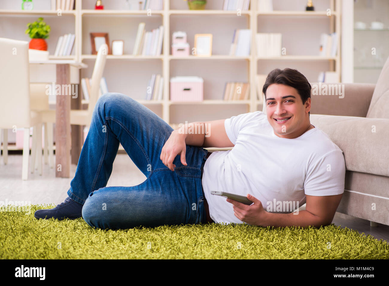 Man watching tv at home on floor Stock Photo - Alamy