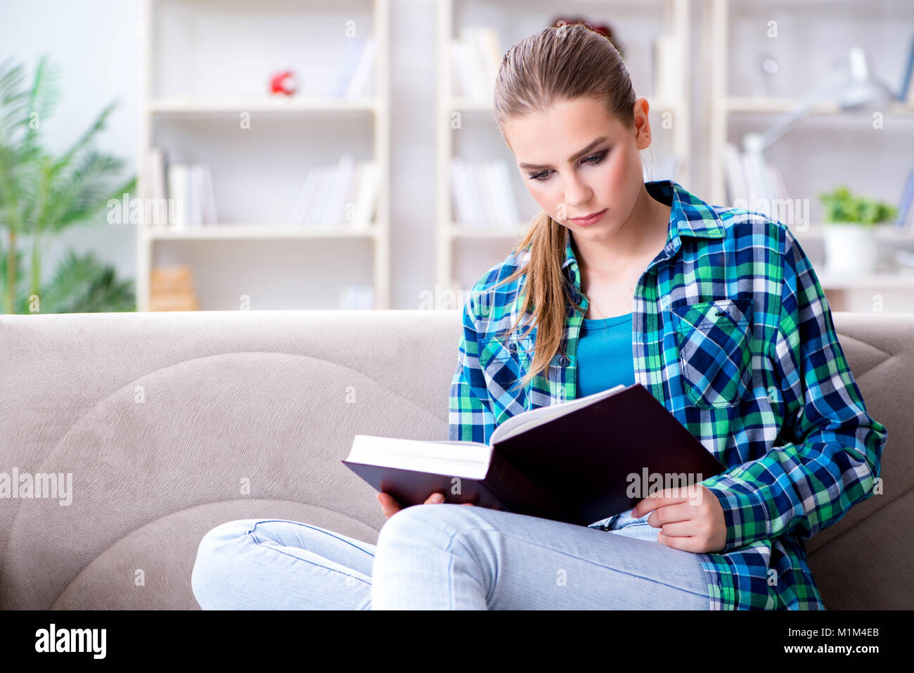 Teen girl reading book couch hi-res stock photography and images - Alamy
