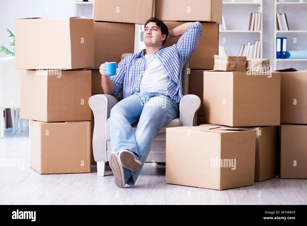 Young man moving in to new house with boxes Stock Photo - Alamy