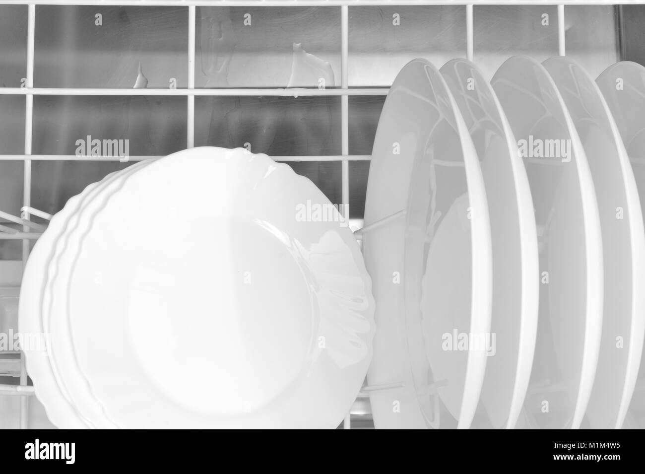 Background with white dish in a basket dishwasher, from above. The dish ...