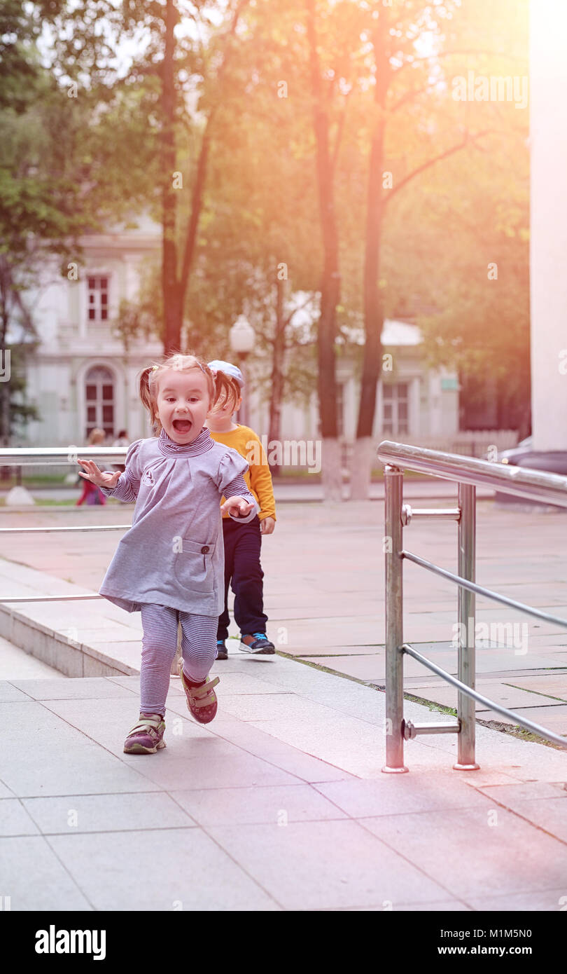 Children on a walk in the spring in the city park. The girl is w Stock ...