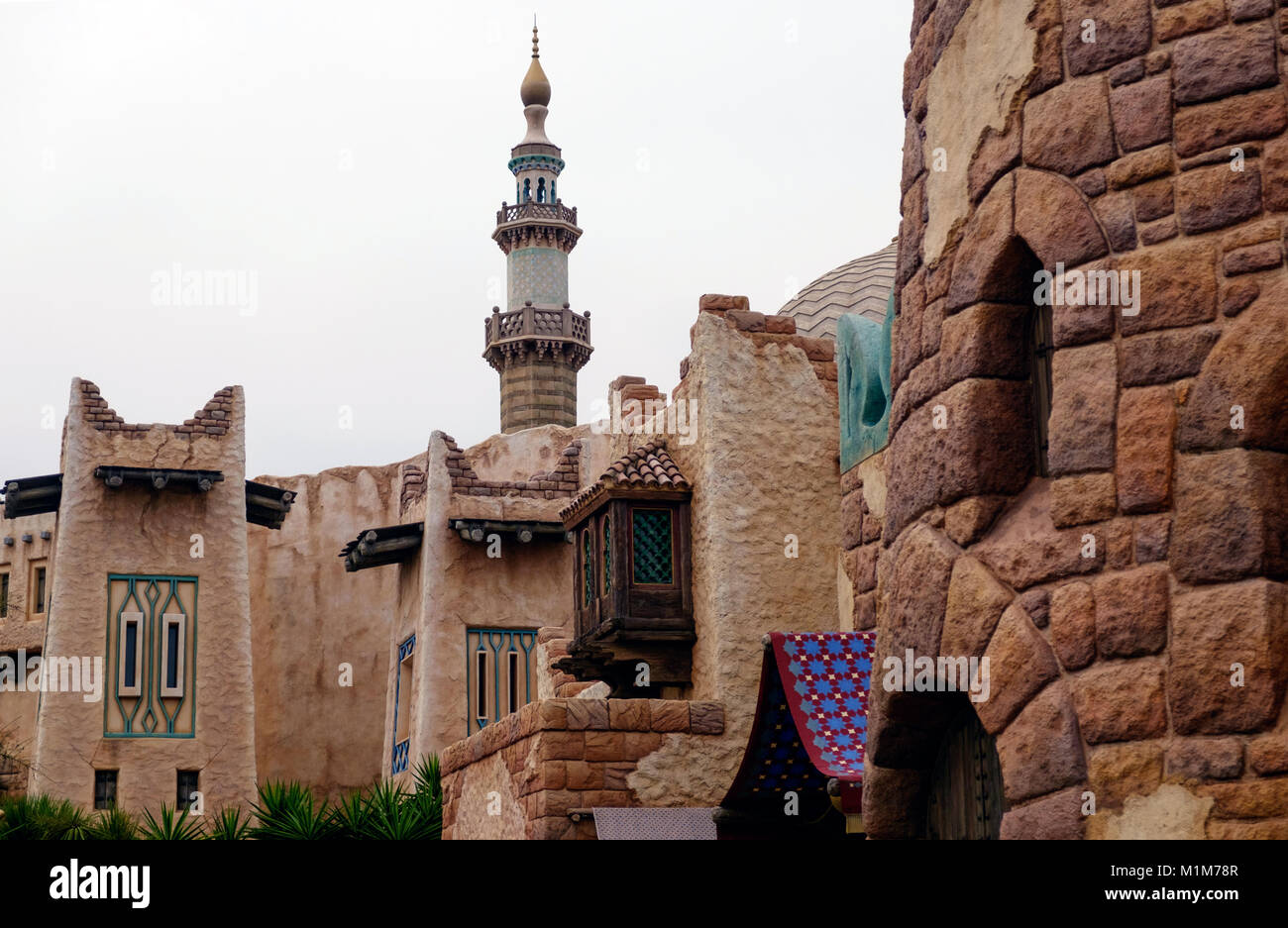 Arabic style buildings and a prayer tower with golden top. At Arabian ...