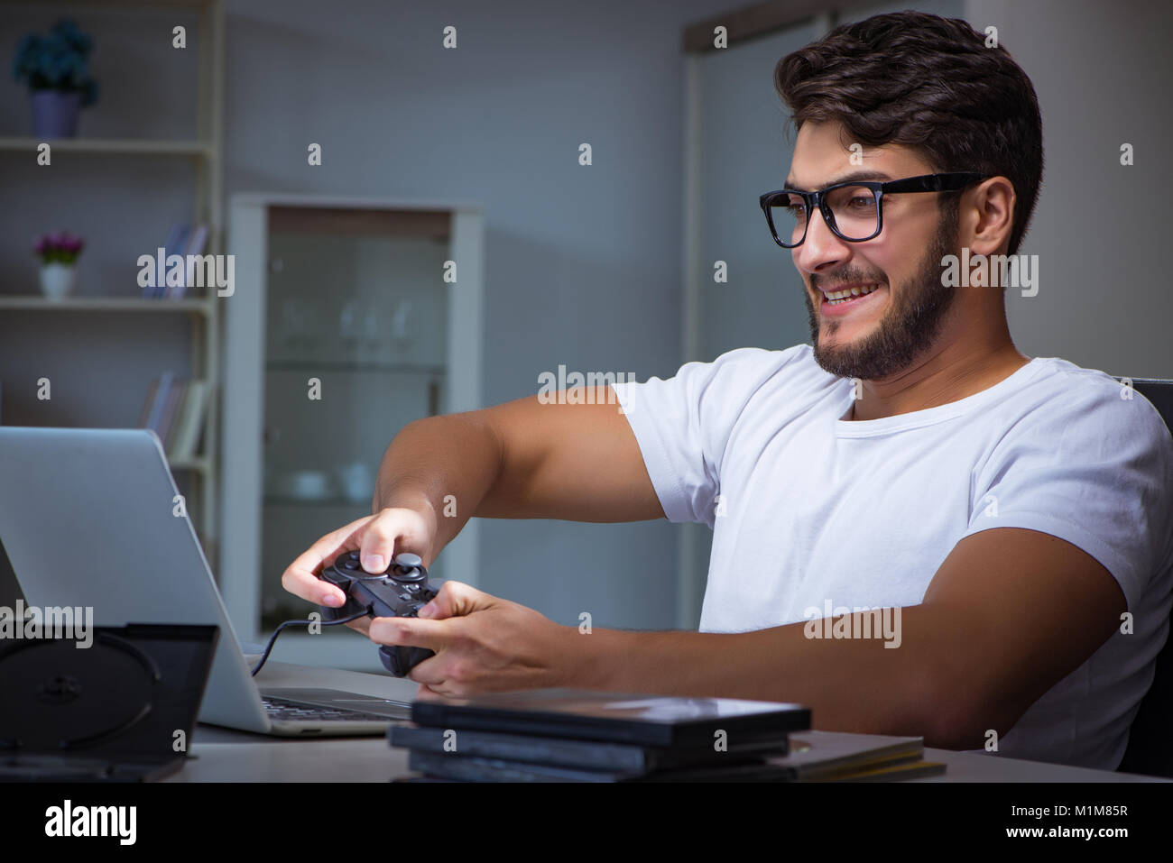 Young man playing games long hours late in the office Stock Photo - Alamy