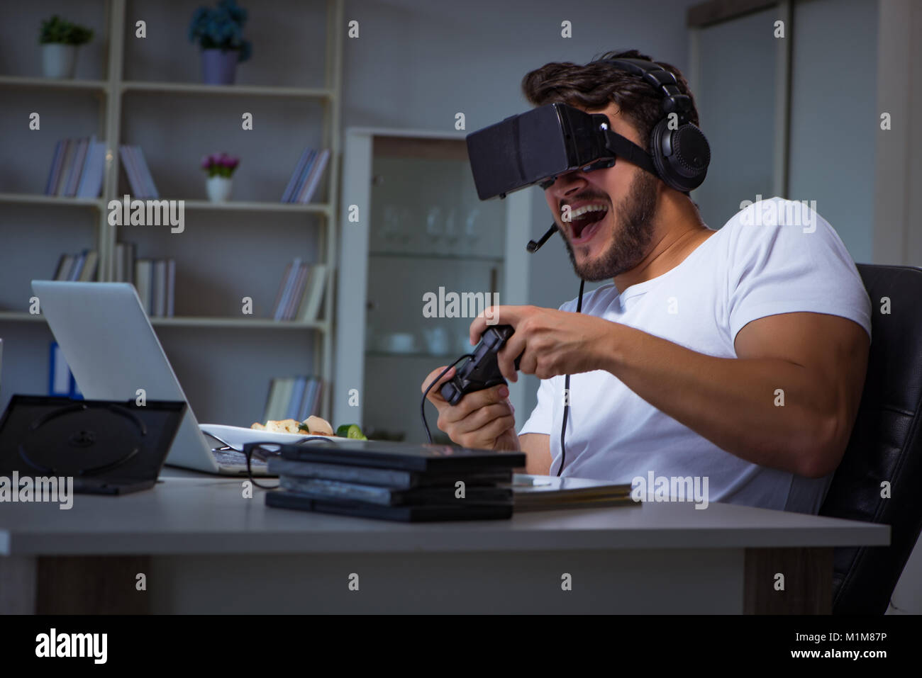 Young man playing games long hours late in the office Stock Photo - Alamy