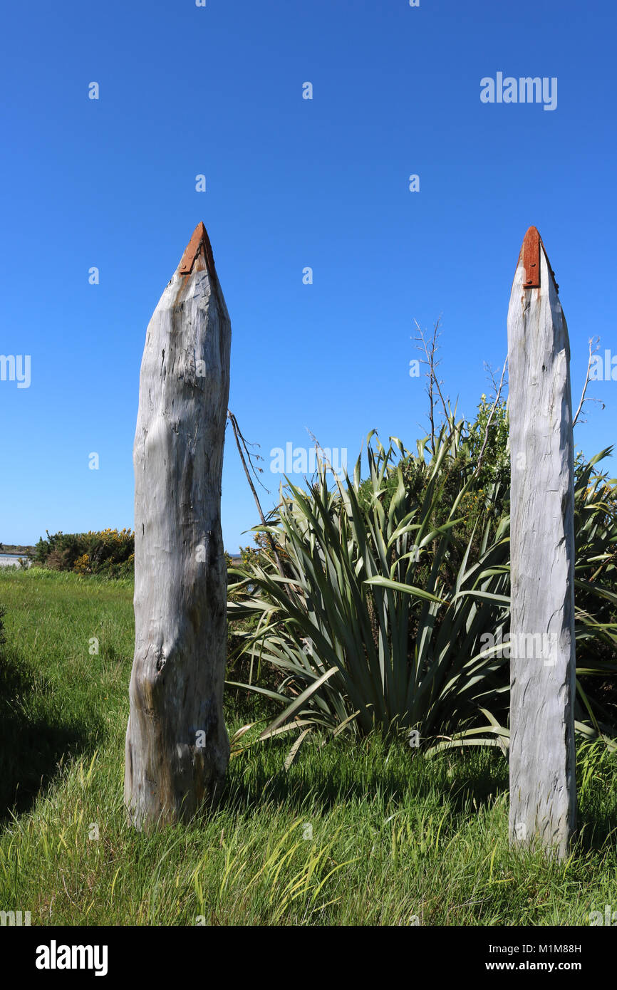 Two metal capped pointed wooden posts standing near Okarito lagoon at ...