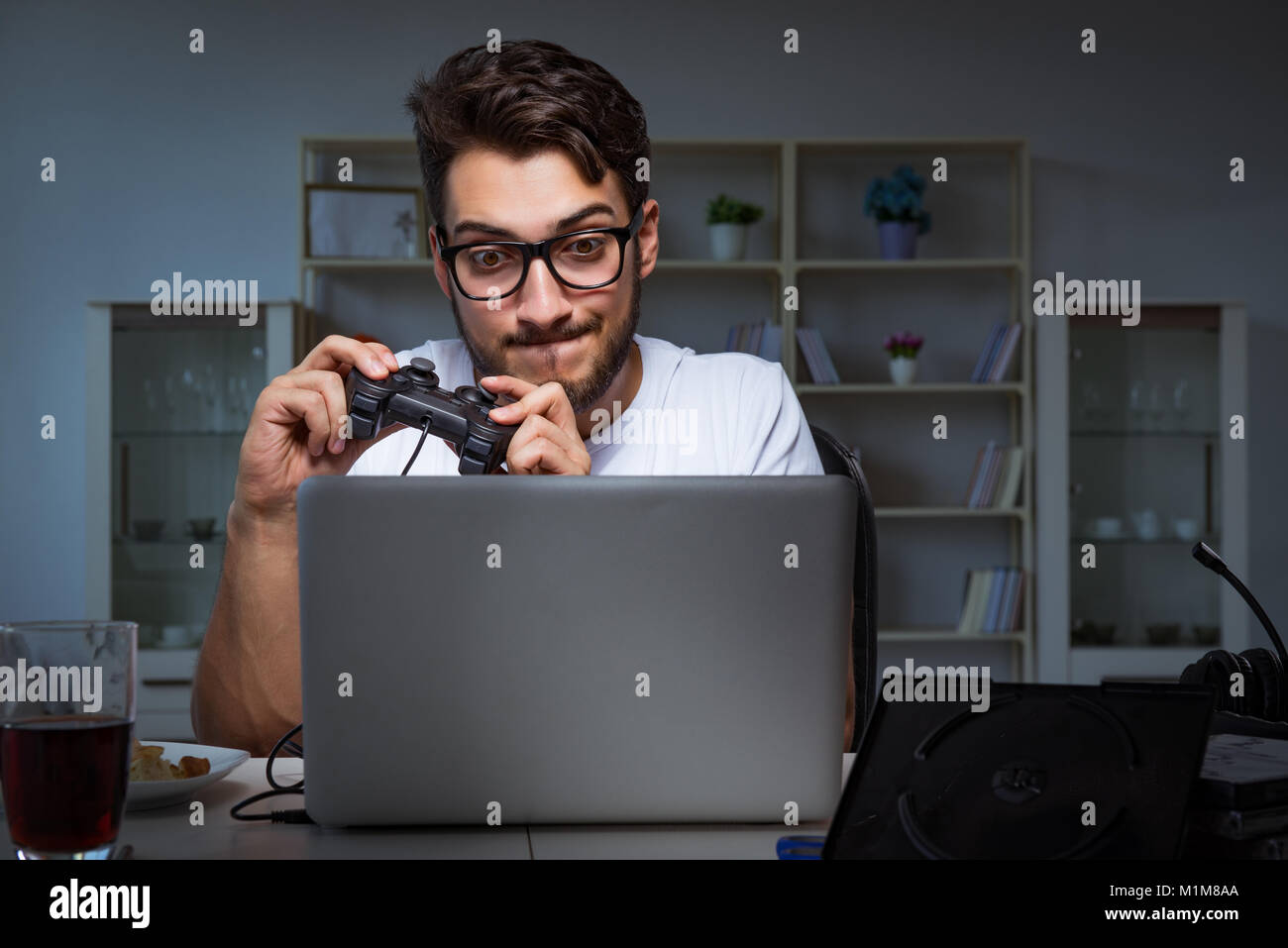 Young man playing games long hours late in the office Stock Photo - Alamy
