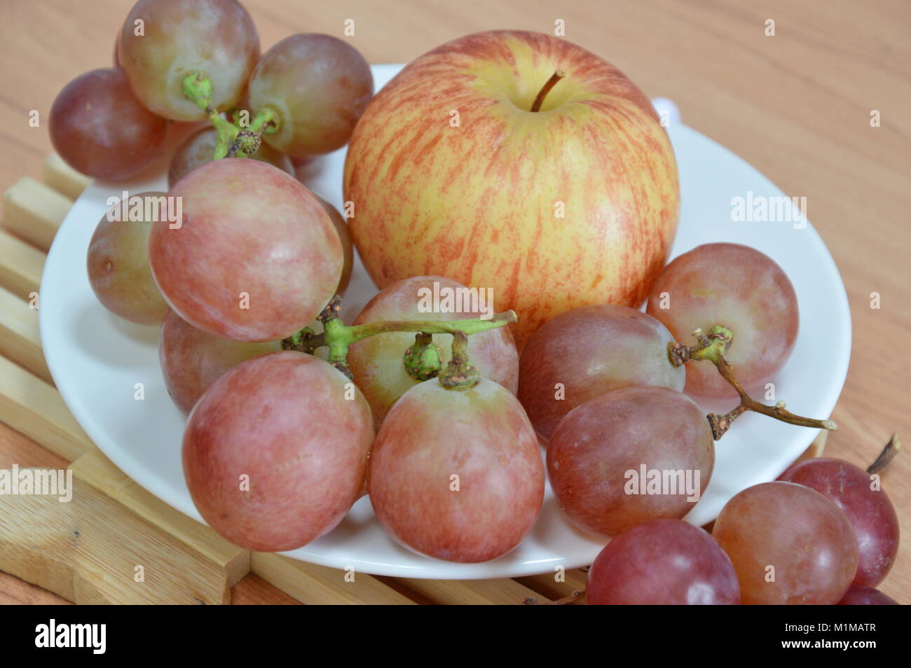 apple and red grape on plate Stock Photo - Alamy