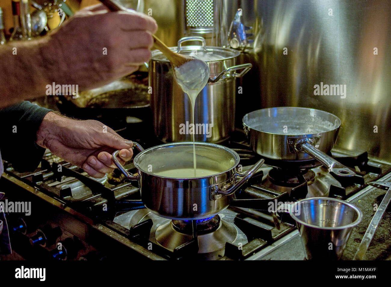man cooking and making white sauce Stock Photo - Alamy