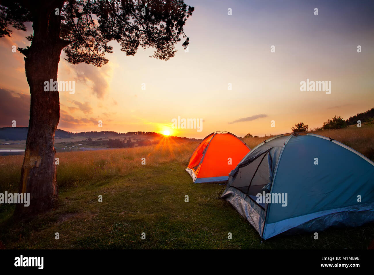 recreation area and camp with tent, sunset time with rising sun near ...