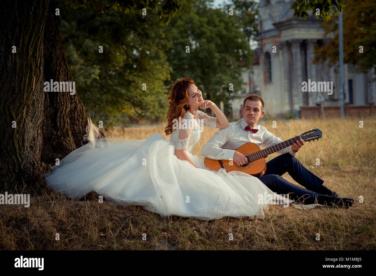 Charming smiling bride is listening to the elegant groom playing the ...