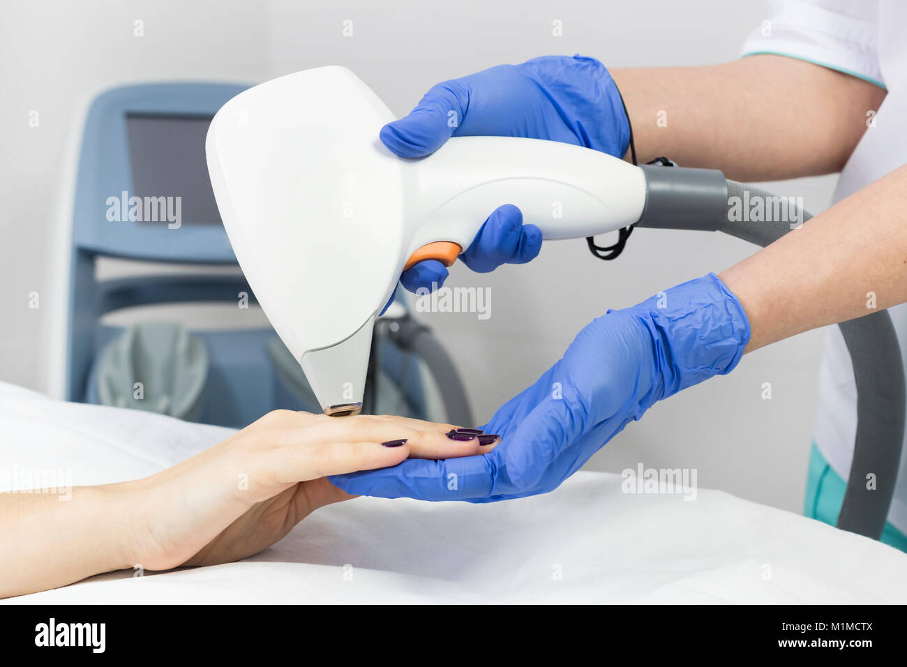 The process of laser depilation of female limbs in the beauty salon ...