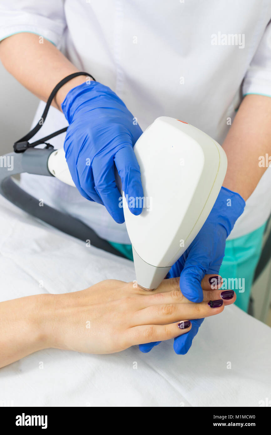 The process of laser depilation of female limbs in the beauty salon ...