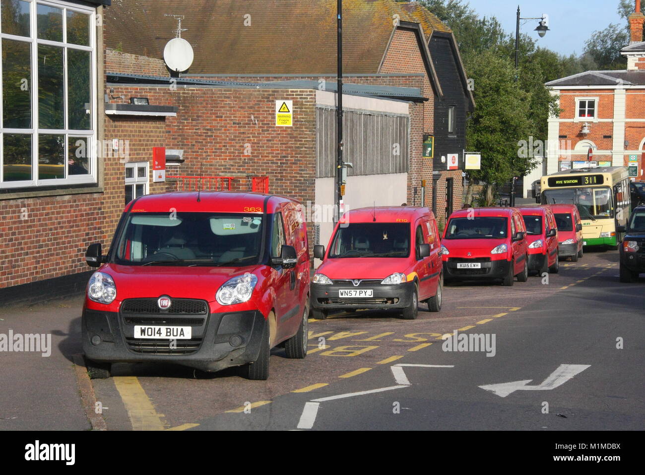 A LINE-UP OF 5 RED ROYAL MAIL DELIVERY VANS WAITING TO START THEIR ...