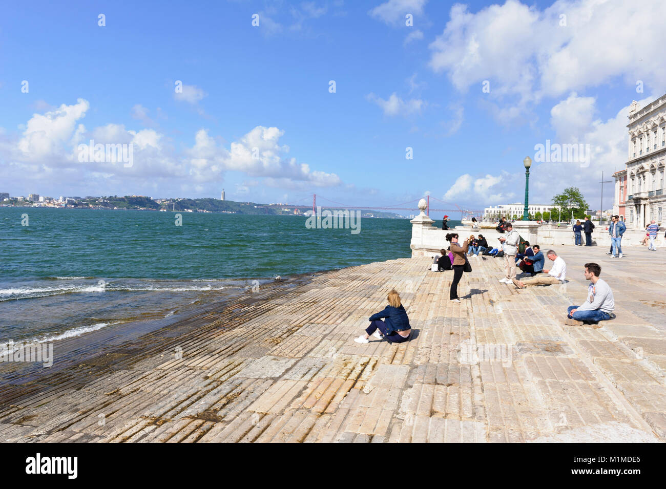 People sitting on the steps leading to the water at The waterfront in ...