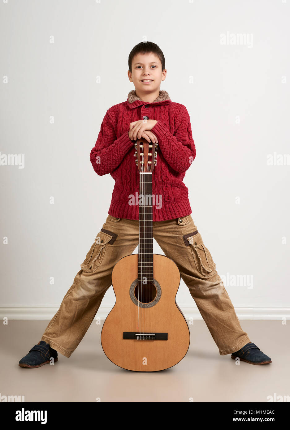 Boy having fun with guitar, making music and singing Stock Photo - Alamy