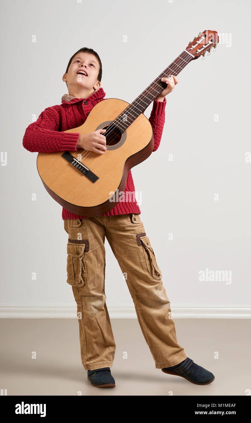 Boy having fun with guitar, making music and singing Stock Photo - Alamy