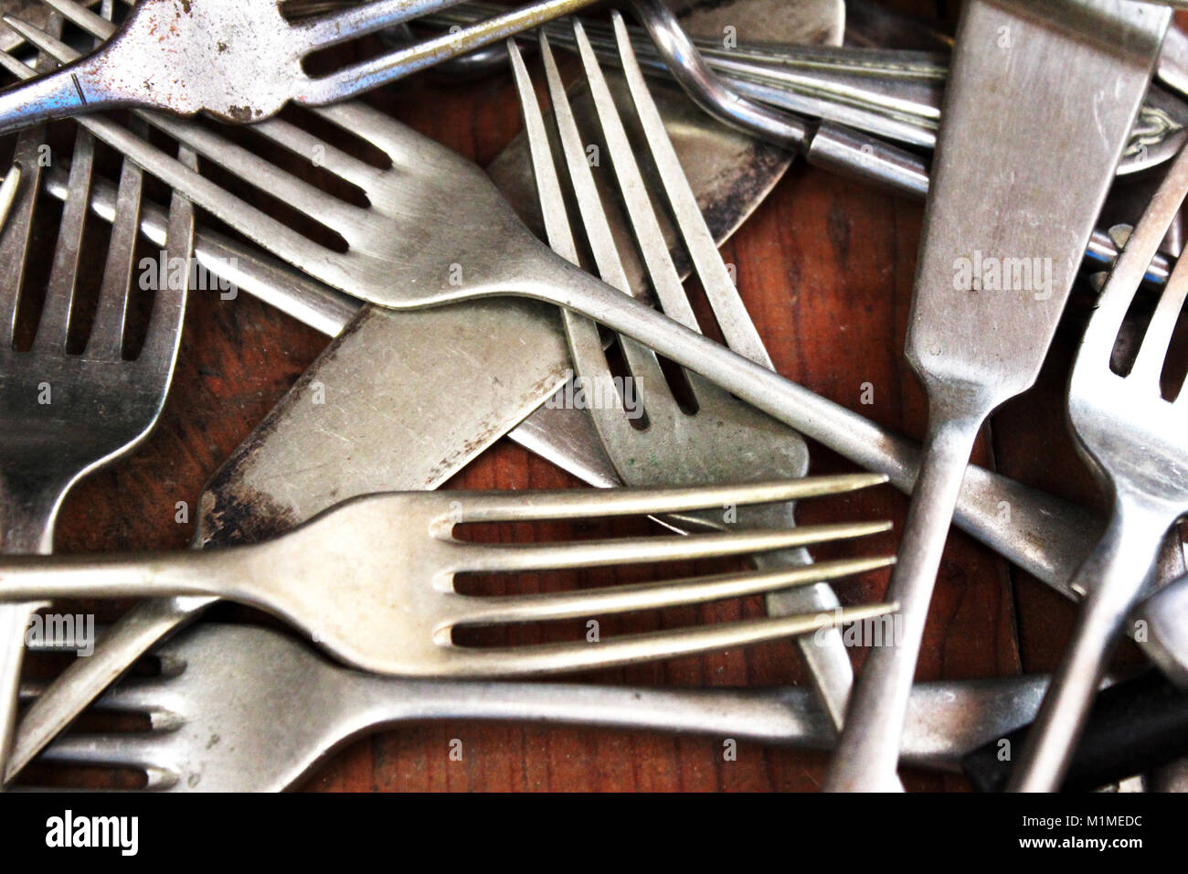 Long forks scattered across an oak countertop Stock Photo - Alamy