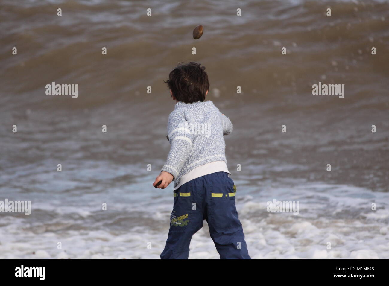 Boy Throwing Pebbles Into The Sea High Resolution Stock Photography and ...