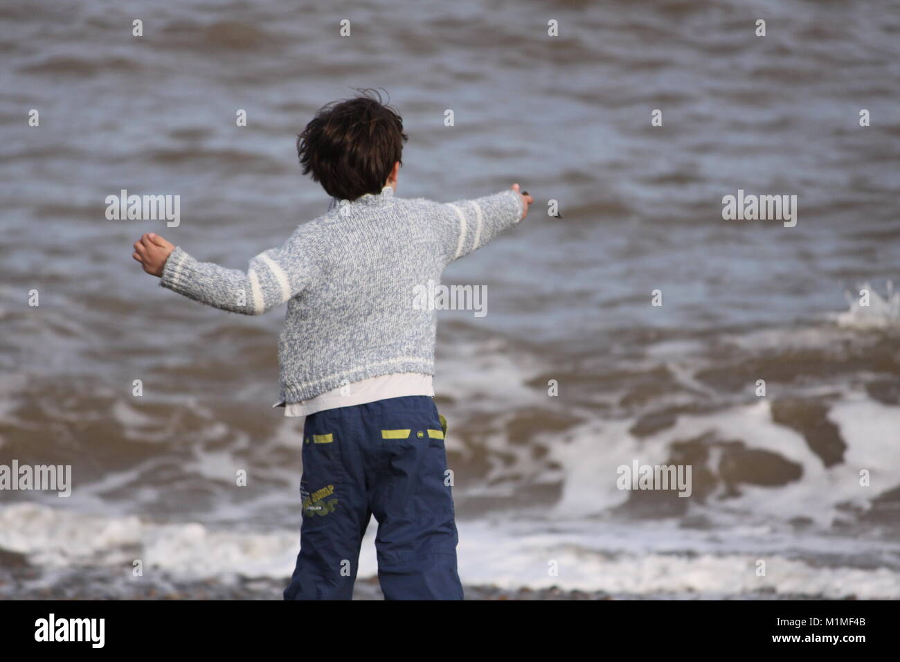 Boy Throwing Pebbles Into The Sea High Resolution Stock Photography and ...
