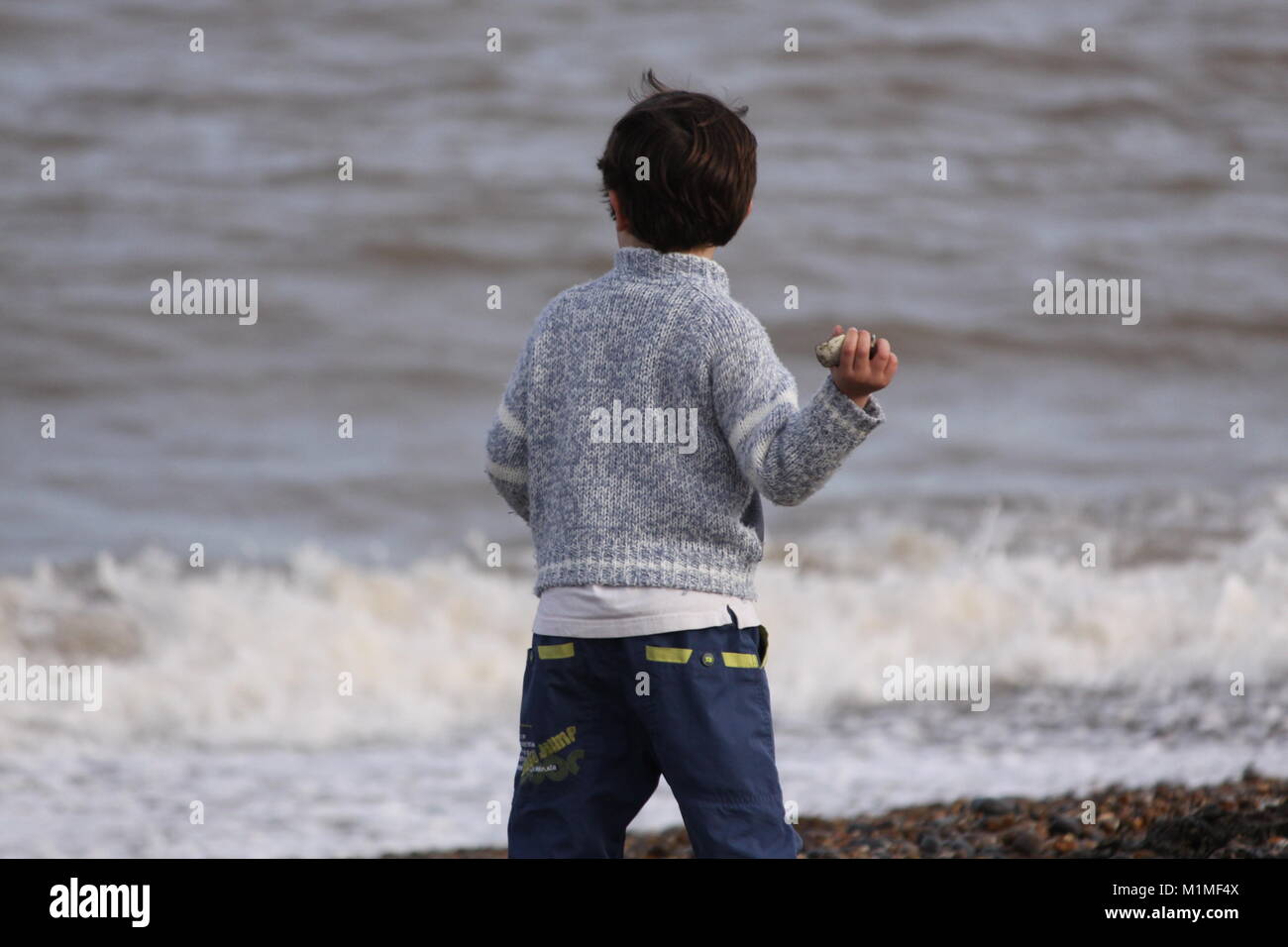 Boy Throwing Pebbles Into The Sea High Resolution Stock Photography and ...