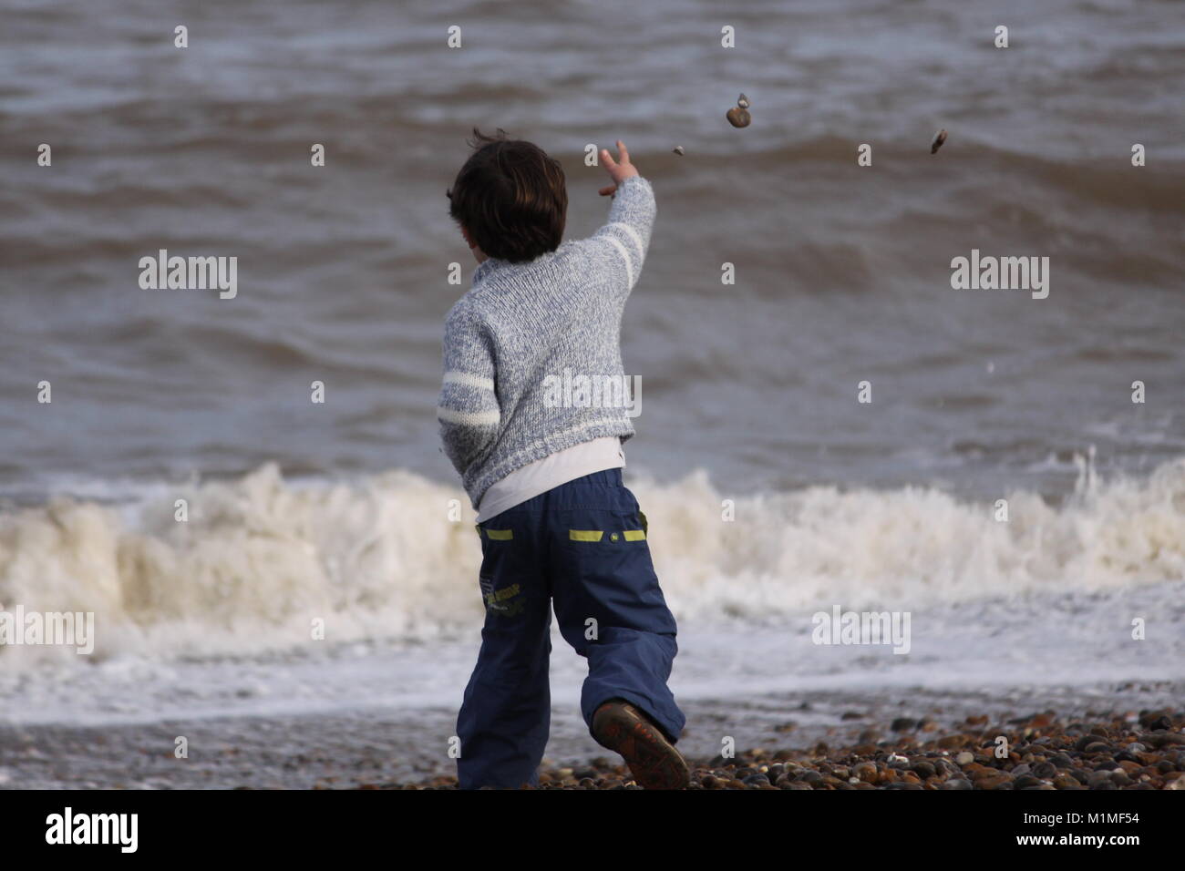 Boy Throwing Pebbles Into The Sea High Resolution Stock Photography and ...