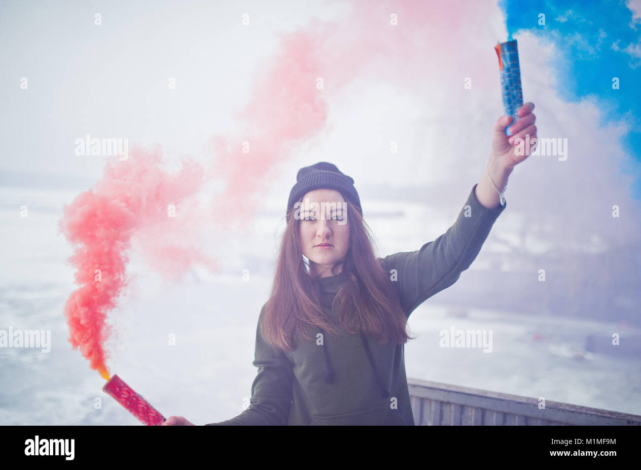 Young girl with blue and red colored smoke bomb in hands Stock Photo ...