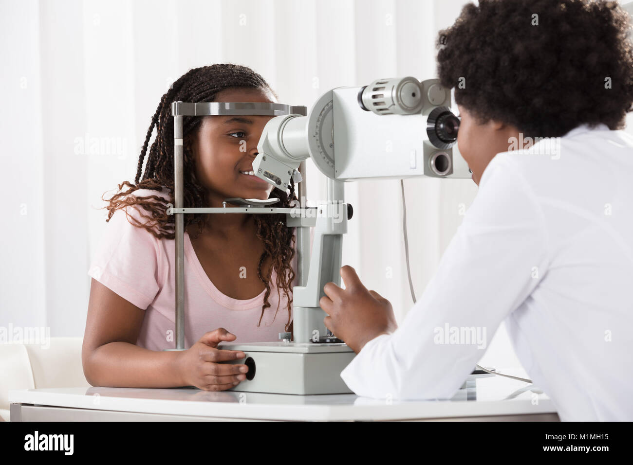 Female Optometrist Examining Patient On Phoropter In Ophthalmology ...