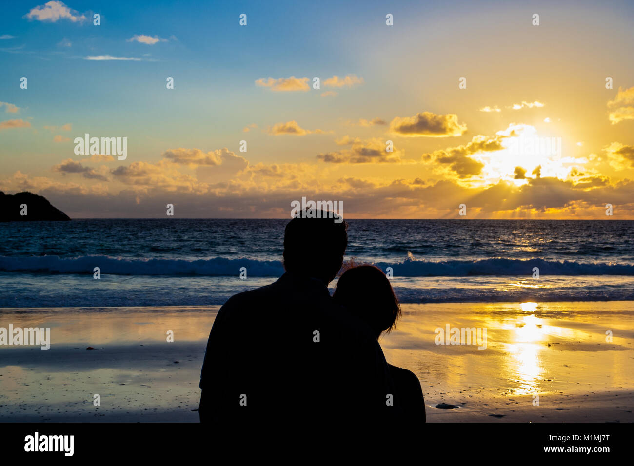 The Rear View Silhouette Of A Loving Couple Holding Each Other During