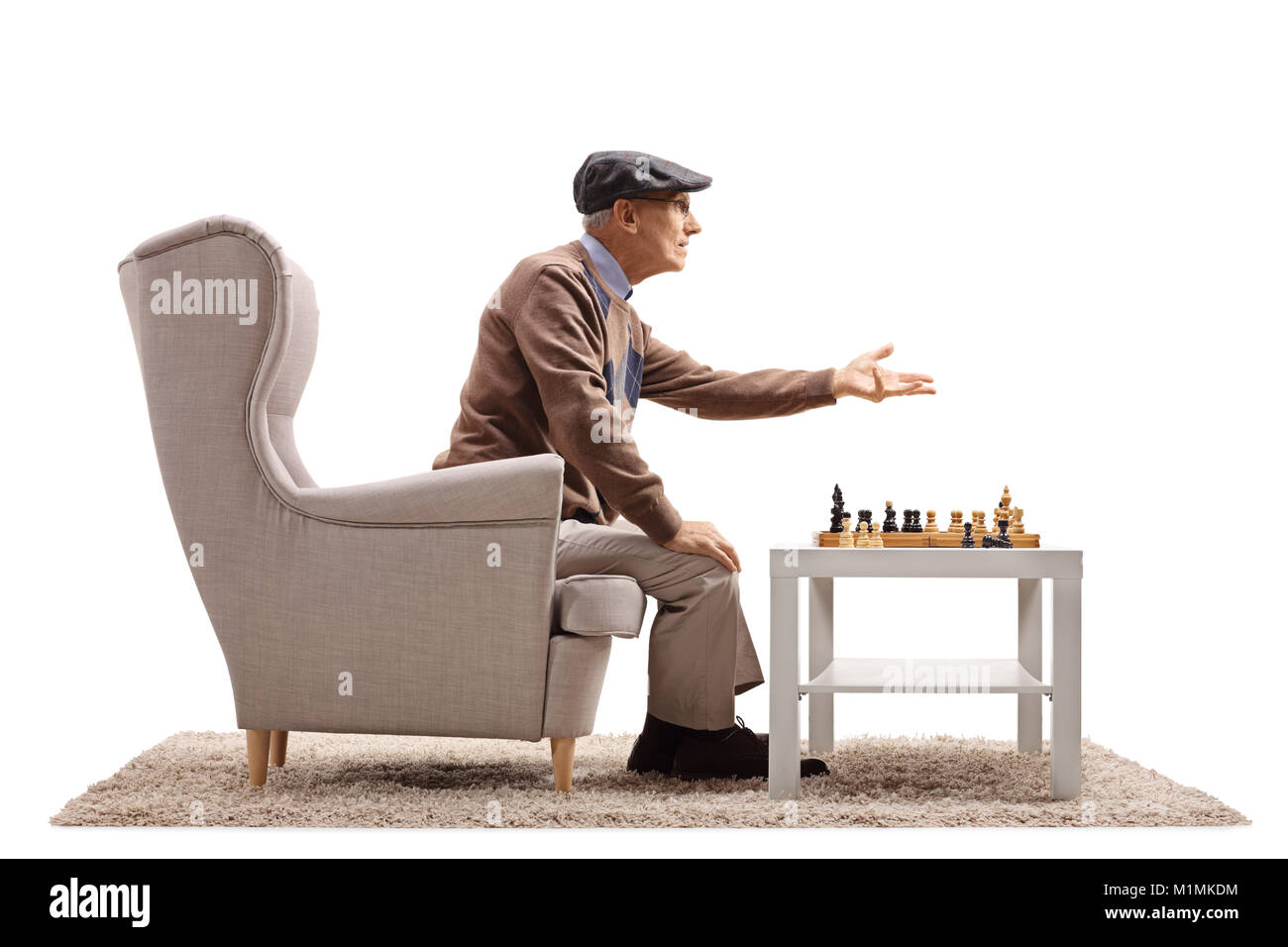 Mature man seated in an armchair playing a game of chess and arguing ...