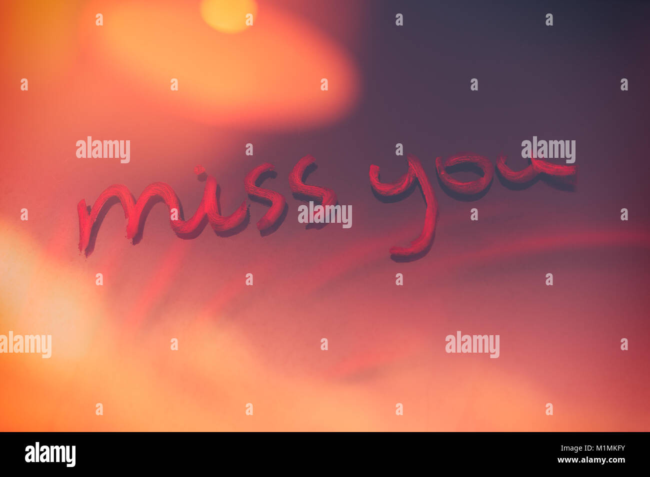 Handwritten phrase miss you on the window glass, abstract background ...