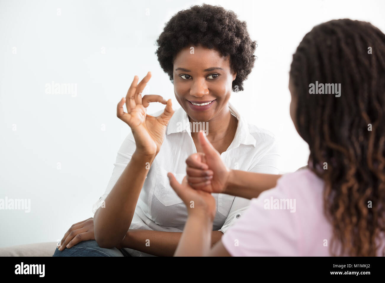 Smiling Young Mother Learning Sign Language To Talk With Her Hearing ...