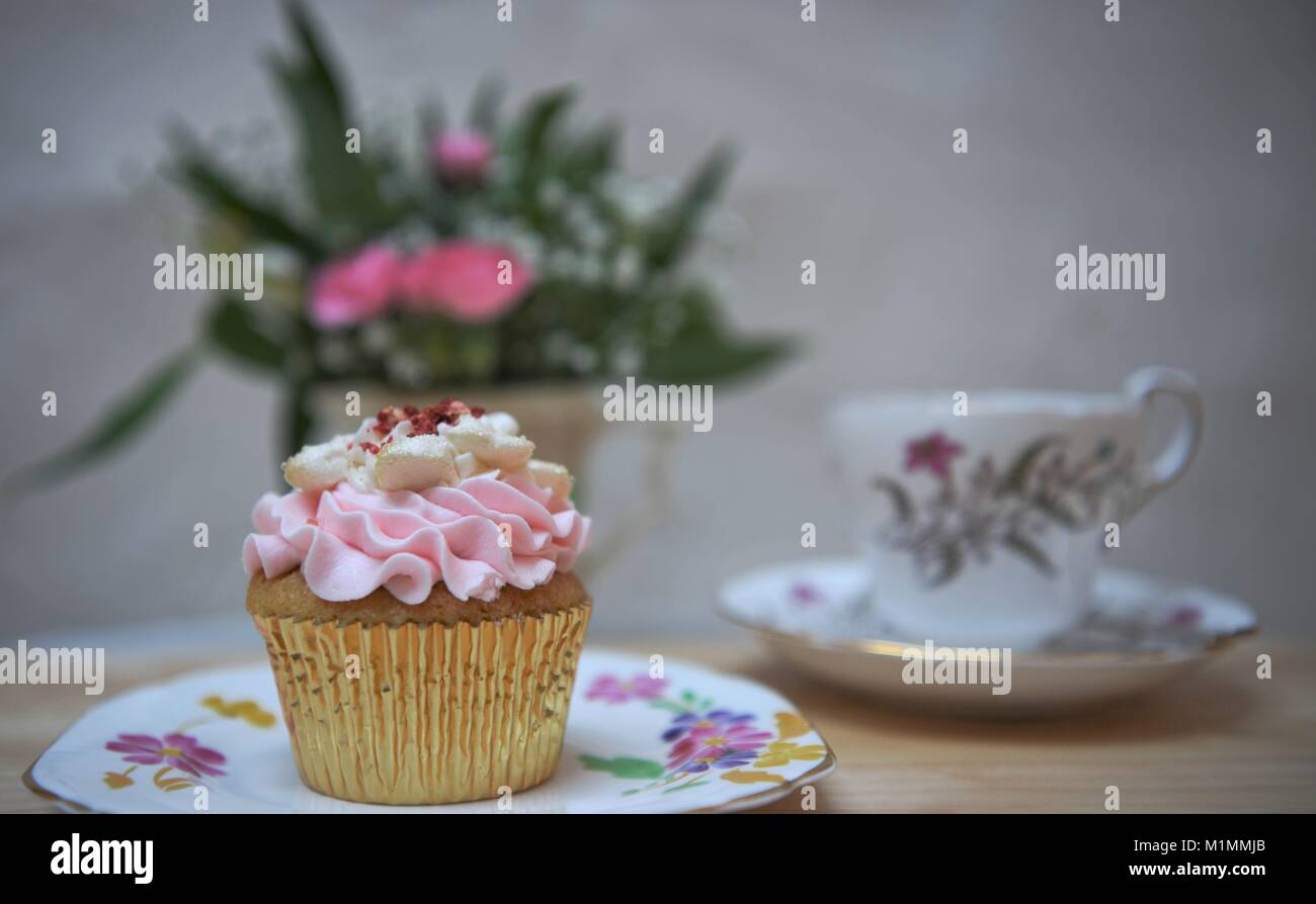 a delicious cupcake with pink and white frosting and old fashioned ...
