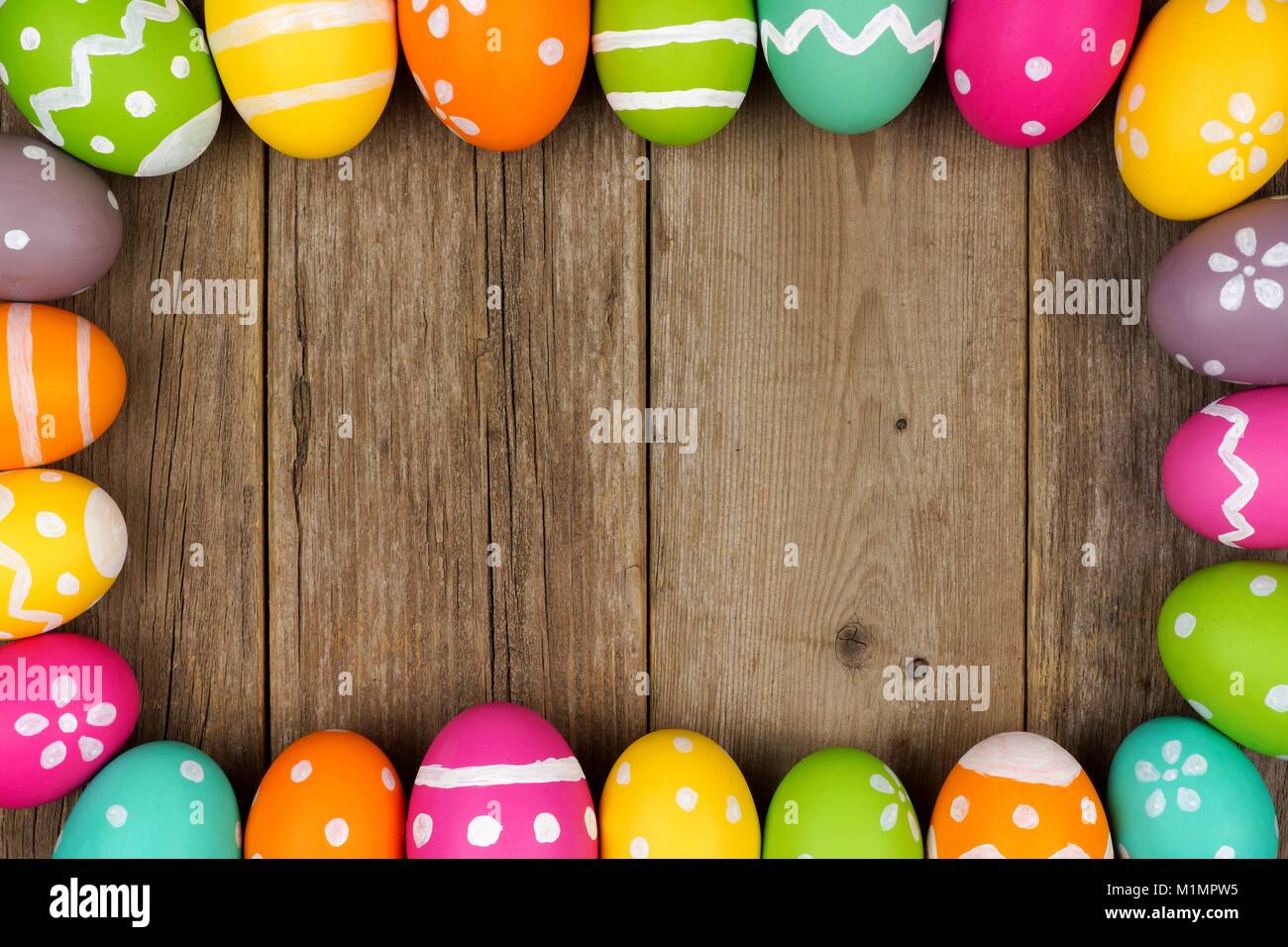 Colorful Easter egg frame against a rustic wood background Stock Photo ...