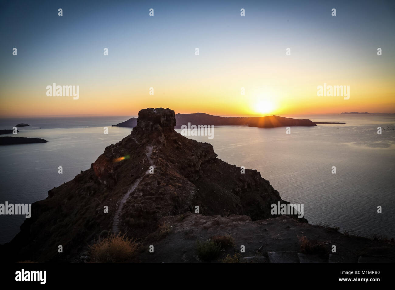 Skaros rock and Thirasia at the background with sun setting, Santorini ...
