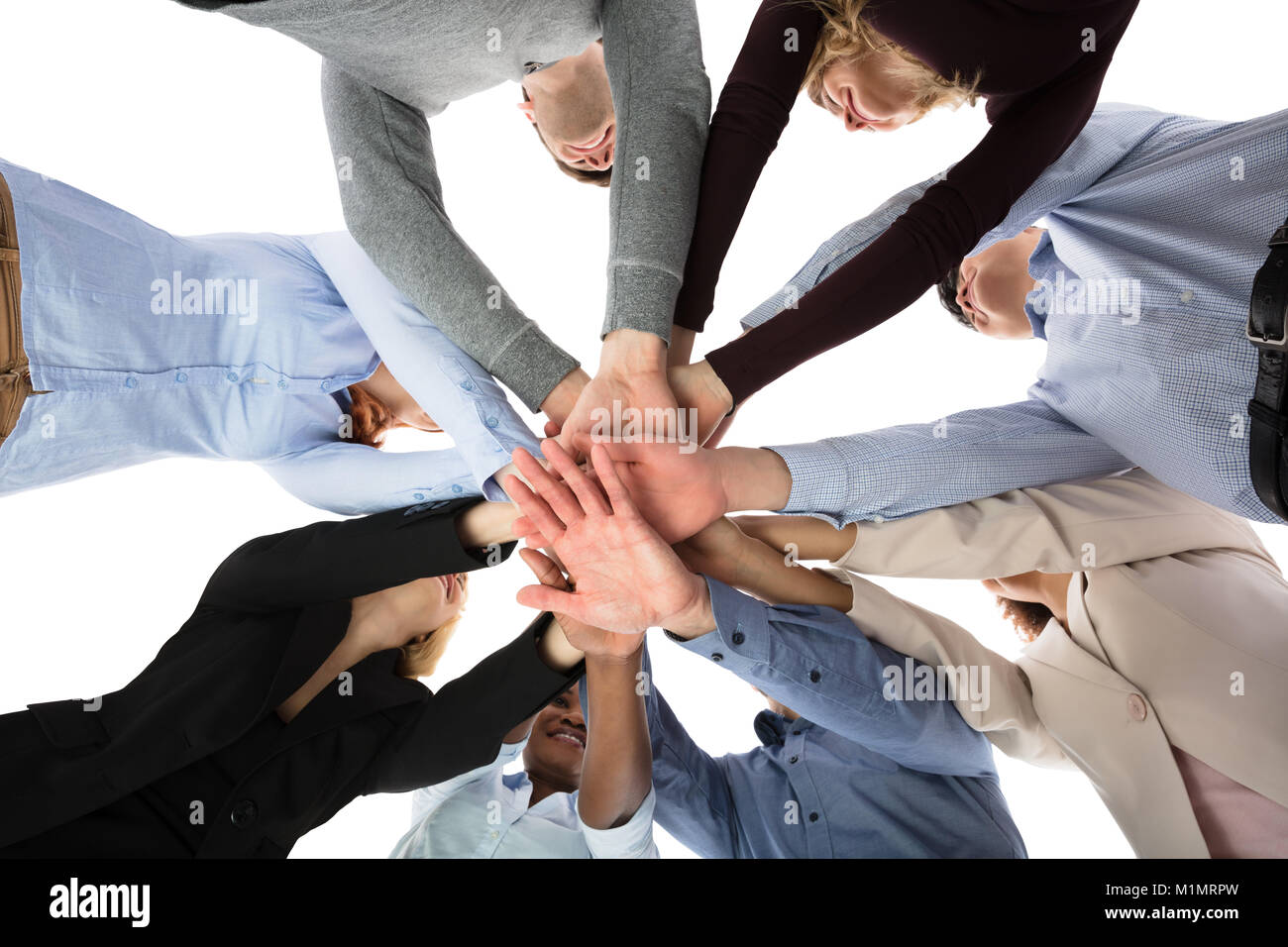 Low Angle View Of College Students Stacking Their Hands Against White ...