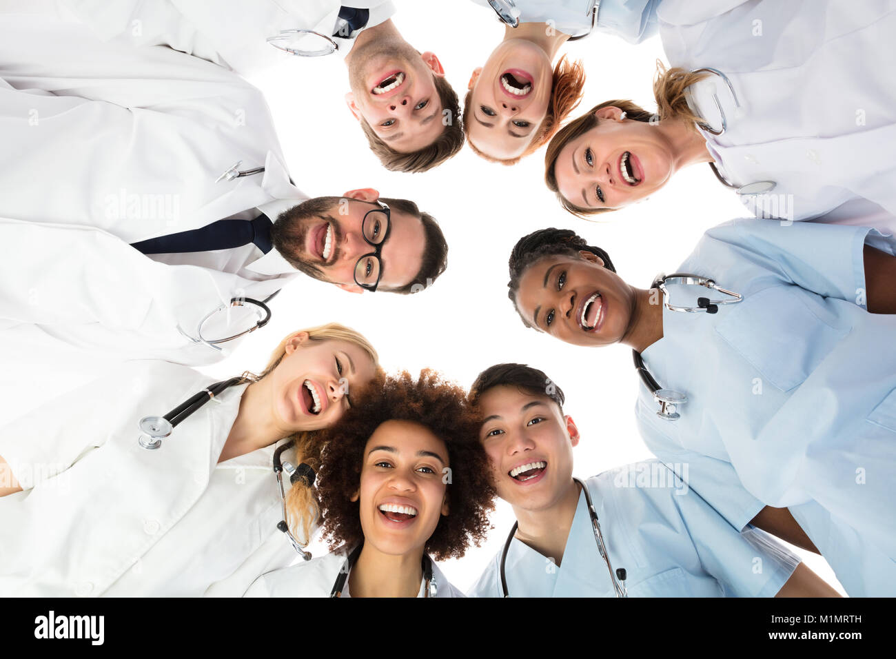 Low Angle View Of Smiling Medical Team Standing Against White ...