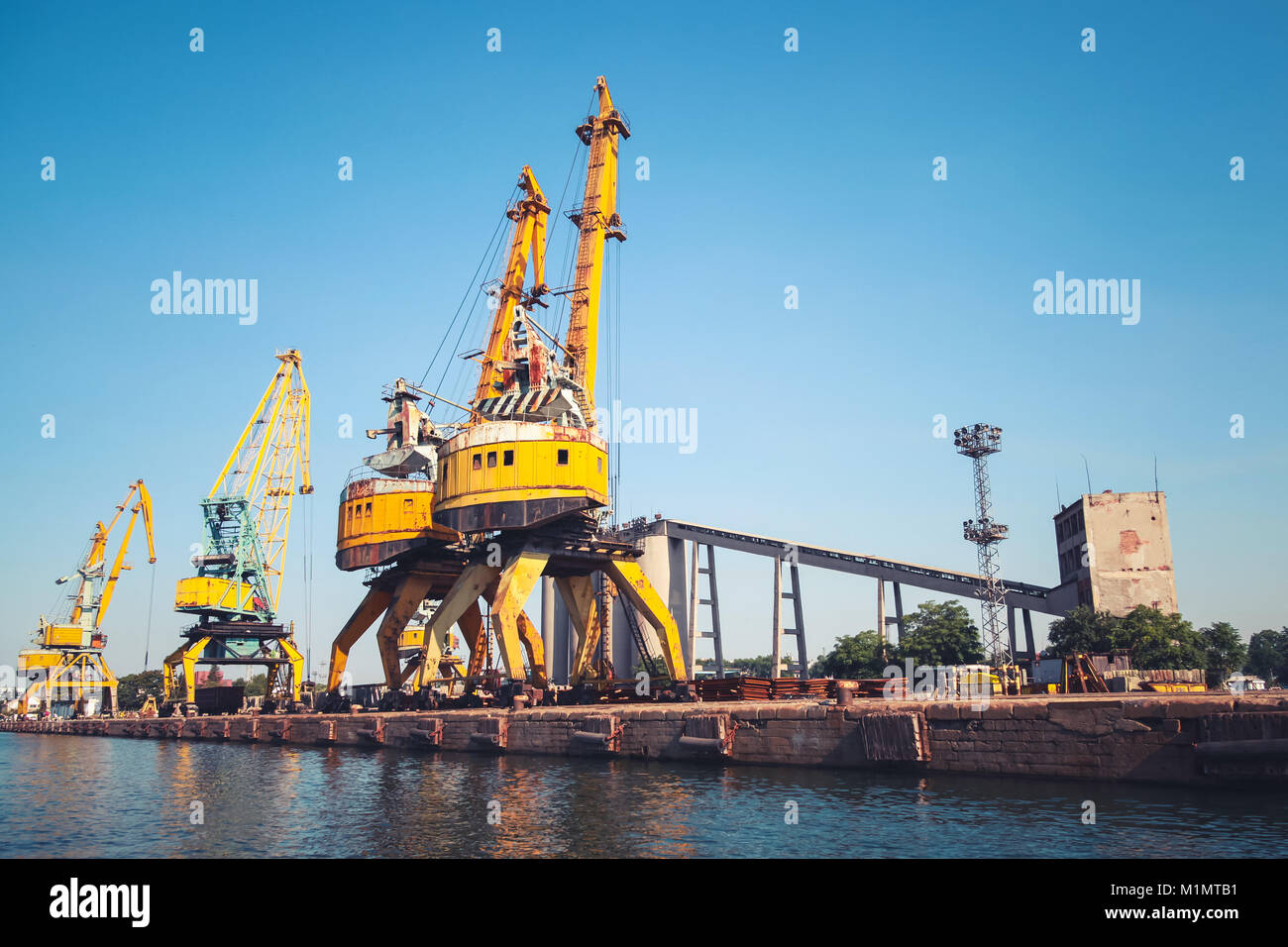 Yellow port cranes stand on the pier in Burgas harbor, Black Sea ...