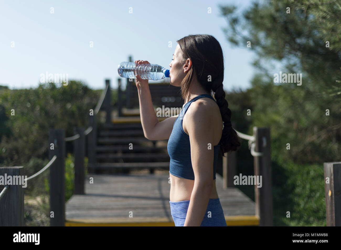 woman drinking water from a bottle after running. Outside Stock Photo ...