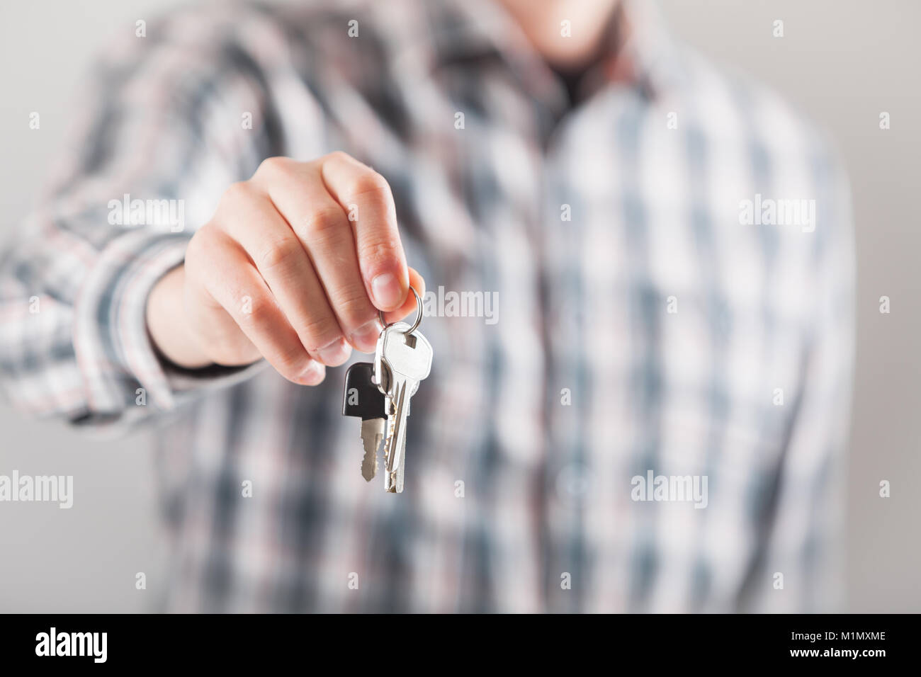 Bright picture of man hand holding house keys Stock Photo - Alamy