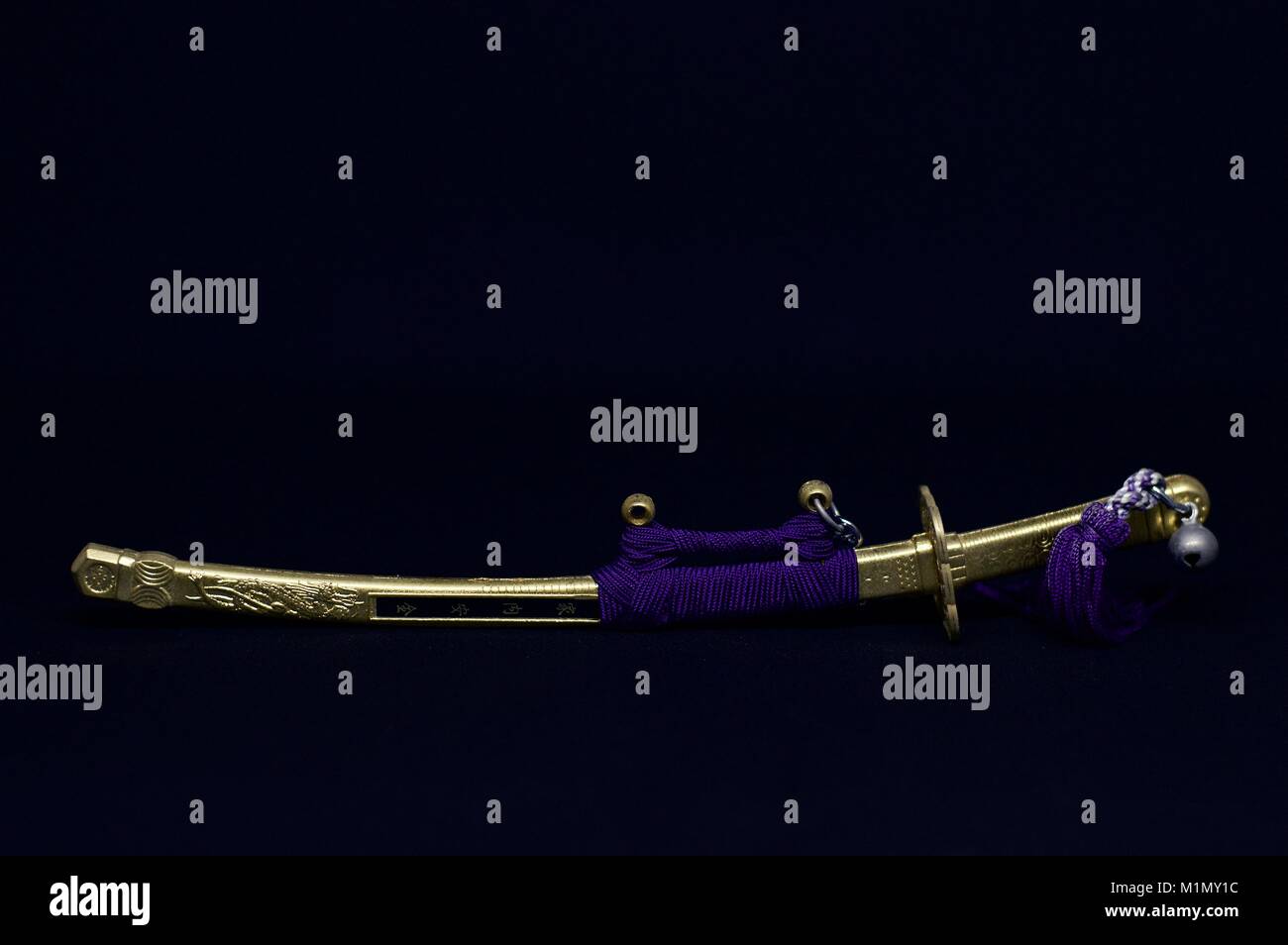 Miniature replica samurai sword from Japan, pictured against a black ...