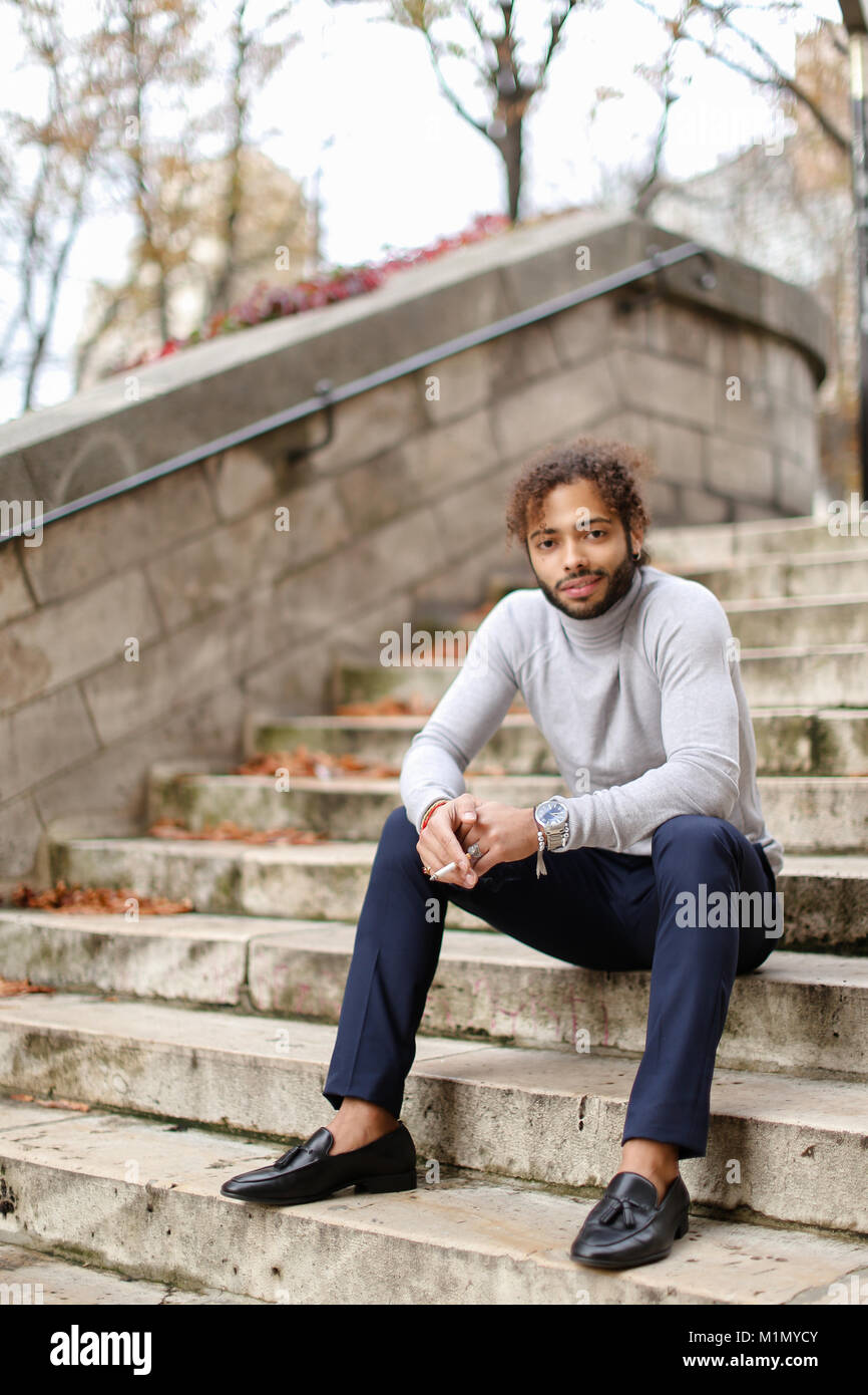 Sad mix blood man smoking on steps Stock Photo - Alamy