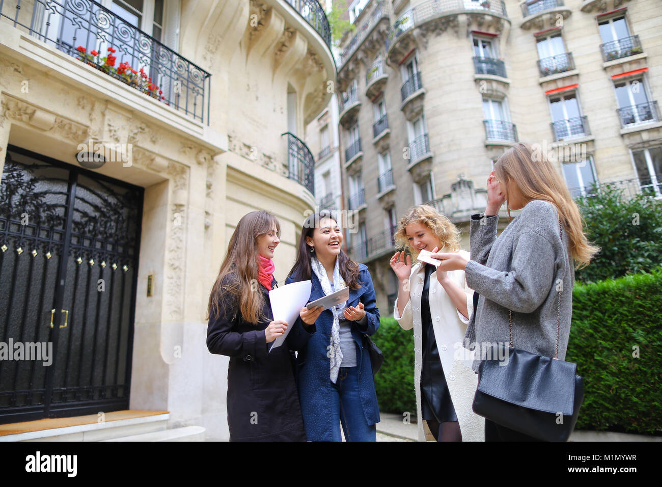 Happy female students talking outside in near university build Stock ...
