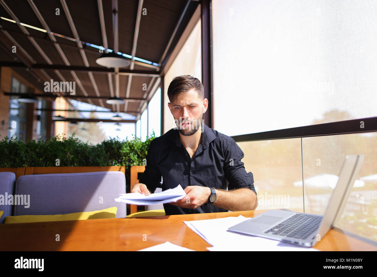 Office worker sorting papers on table near laptop Stock Photo - Alamy
