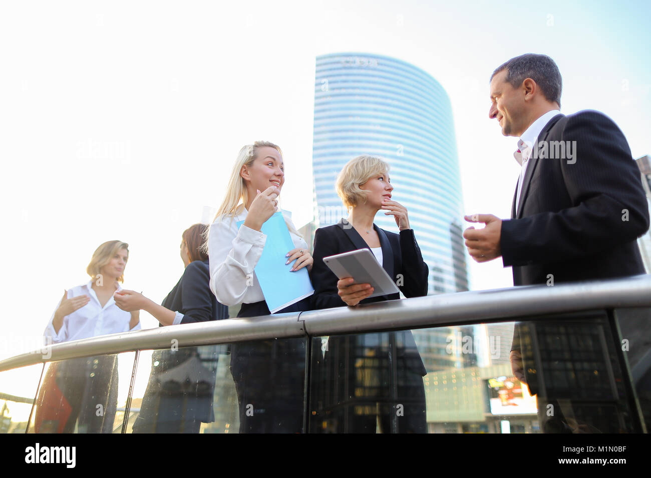 Businesswomen speaking with male boss outside Stock Photo - Alamy