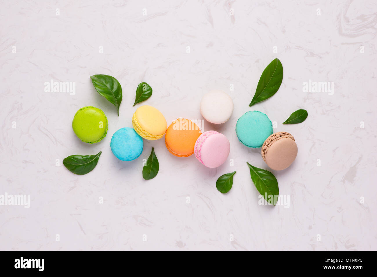 Spring concept with macaroons and green leaves. Top view Stock Photo ...