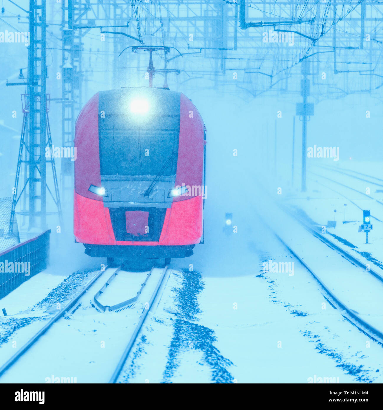 Highspeed train approaches to the station platform at cold snowstormy ...