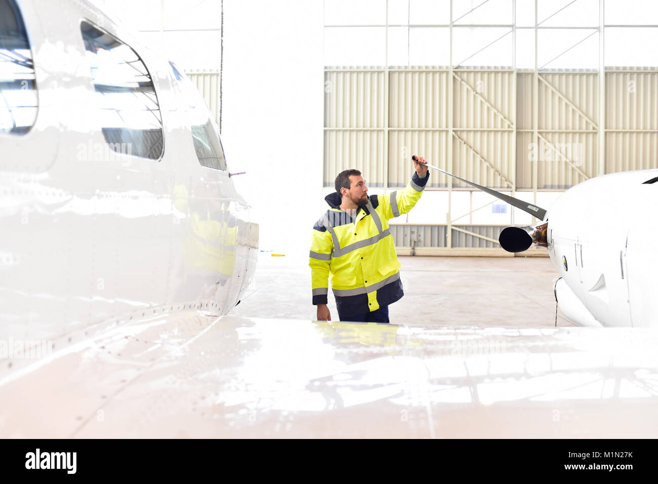 Airport workers check an aircraft for safety in a hangar Stock Photo ...