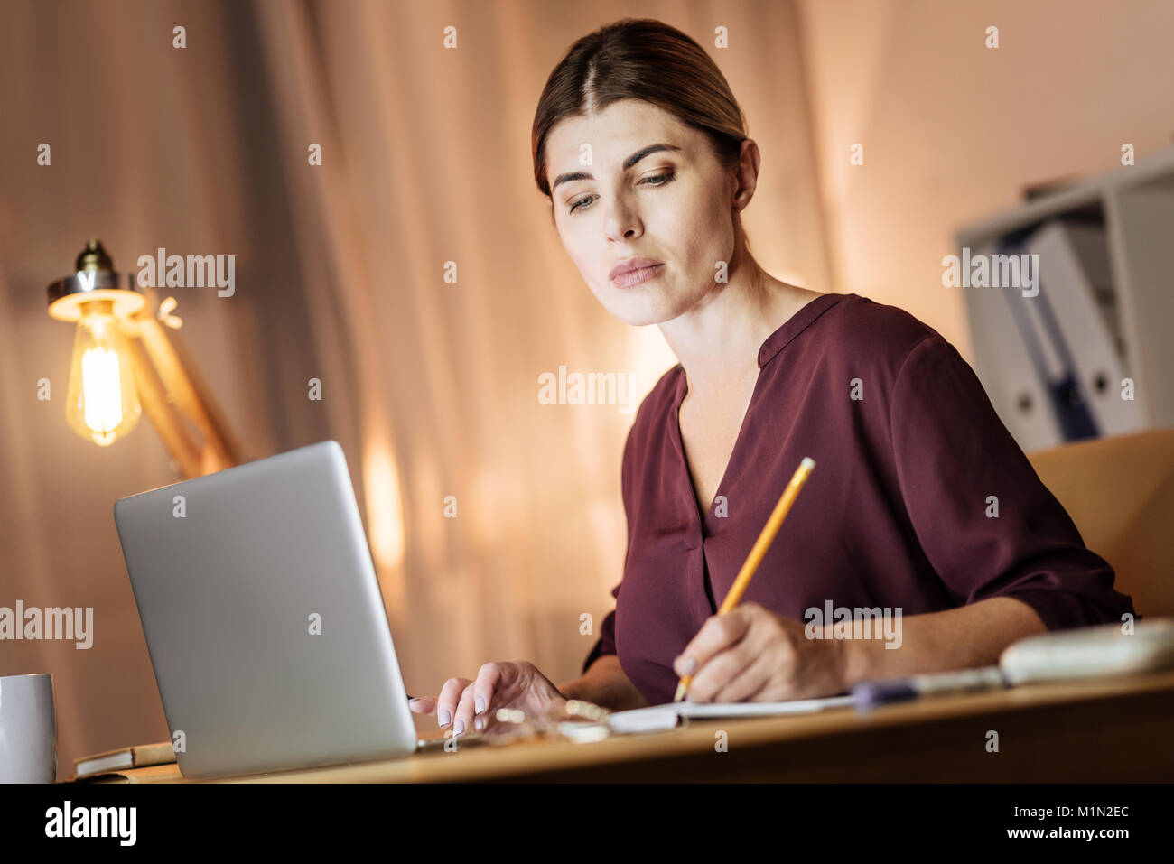 Serious female person making notes Stock Photo - Alamy