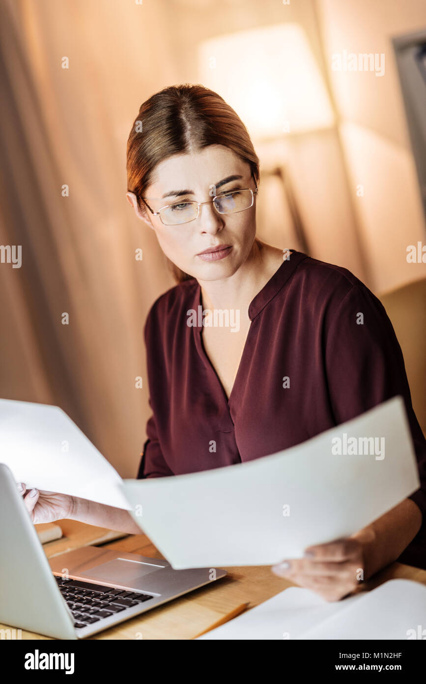 Serious woman checking her documents Stock Photo - Alamy