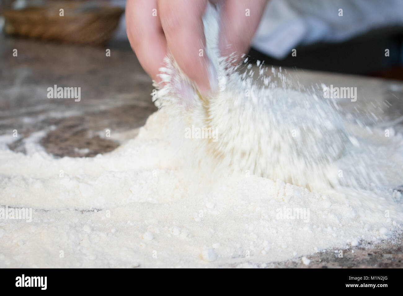 Sprinkle flour on pizza dough Stock Photo - Alamy